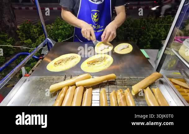 Street vendor prepares delicious mini pancake rolls Stock Video Footage ...