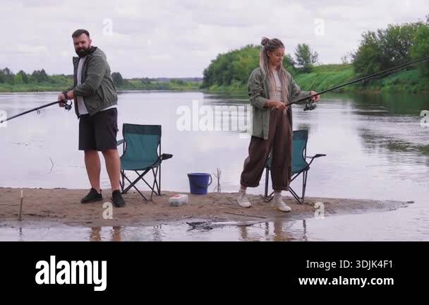 Beautiful young man and woman spending time fishing together on a ...