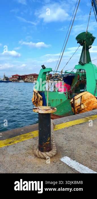 Fishing boat at the dock near the waterfront with buildings in the ...