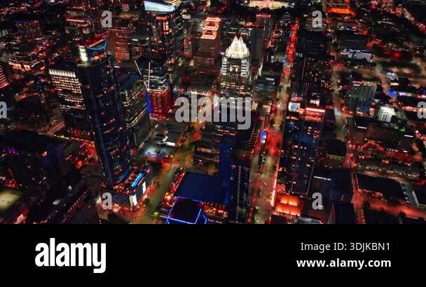 Flying over the neon tops of skyscrapers in the scenery of downtown ...