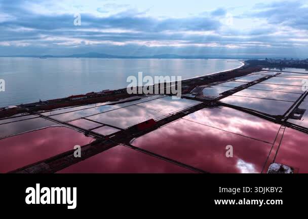 Pink ponds of salt farms reflect clouds in the sky. Seascape with ...