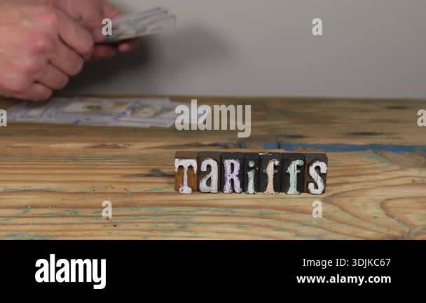Hands Handling Cash Above Table While TARIFFS Represent Import Export ...