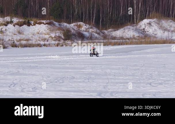 A motorbike rider with white helmet and red black jacket turns on a ...