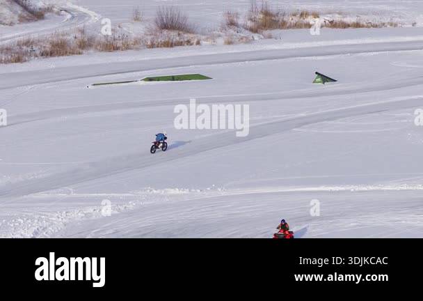 Aerial view shows riders racing on a frozen Latvian lake, carving S ...