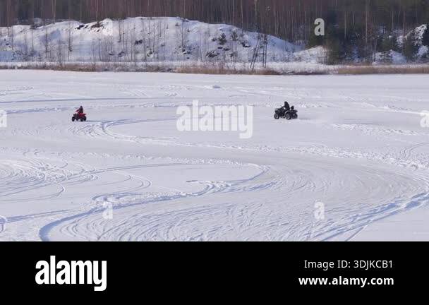 ATVs and quad bikes race and drift on a frozen Latvian lake, aerial ...