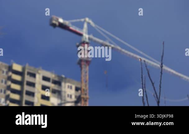A high-rise tower crane at a construction site of an apartment building ...