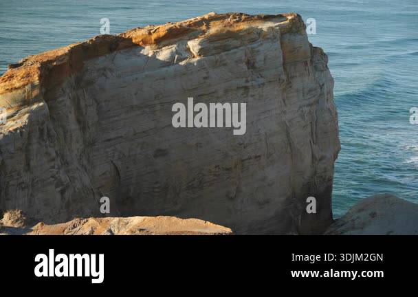 Rocky ocean cliff rising above Pacific shoreline on Oregon coast ...