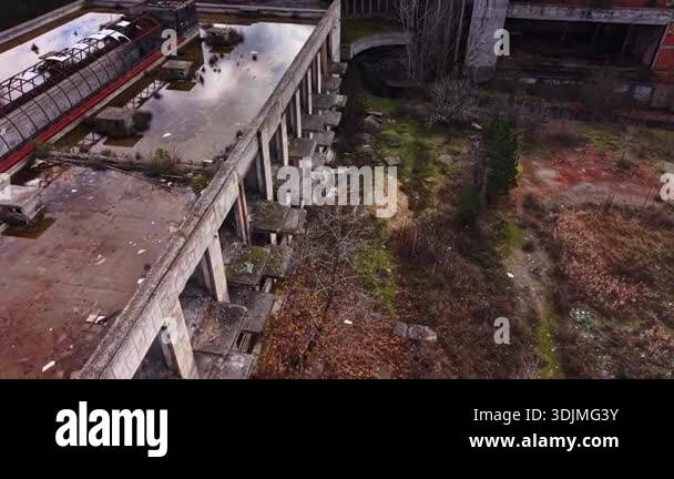 Aerial view of a dilapidated industrial complex surrounded by dense ...