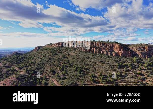 A group of people enjoys hiking on a trail in Spain. The rocky cliffs ...