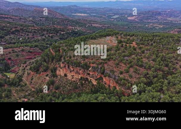 People walk through green hills in Spain. The landscape is full of ...