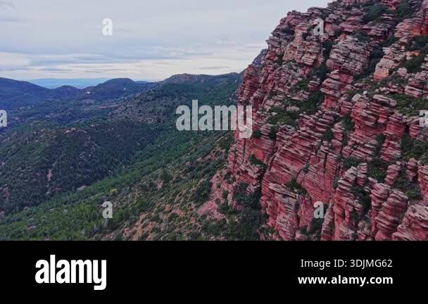 A scene shows tall rocky mountains and green trees in Spain. The ...