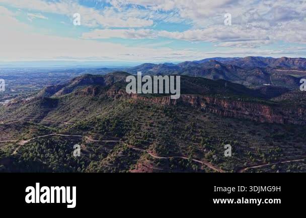 A view of rolling hills and valleys in Spain under a blue sky. Green ...