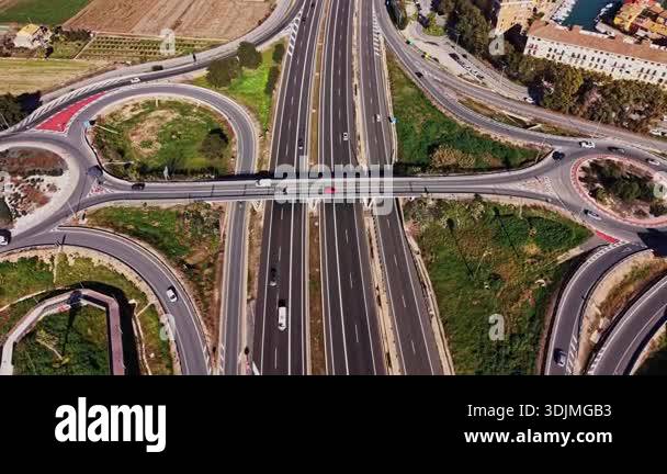 Traffic moves through multiple lanes in a large intersection in Spain ...