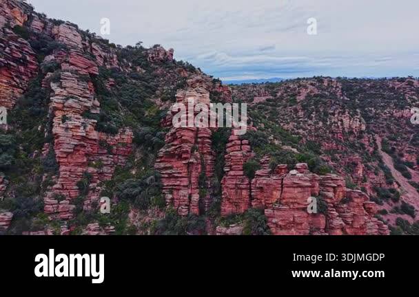 In Spain, rocky cliffs rise steeply against the cloudy sky. The ...