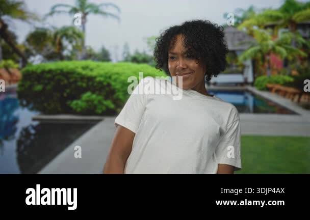 Woman pinches nose and frowns inside building pool area by hotel cabana ...