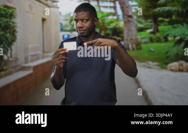 Man holding creditcard and pointing finger toward camera in building ...