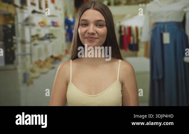 Girl smiling and waving hand in busy clothing store surrounded by shoe ...