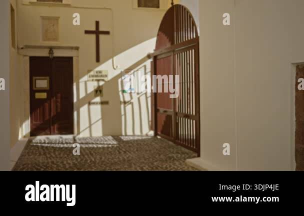 Blurred church interior corridor with arched gate, carved cross and ...