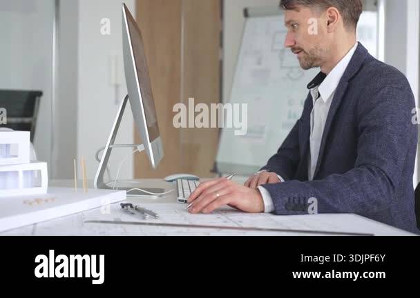 Male architect reviewing digital blueprints and architectural drawing ...