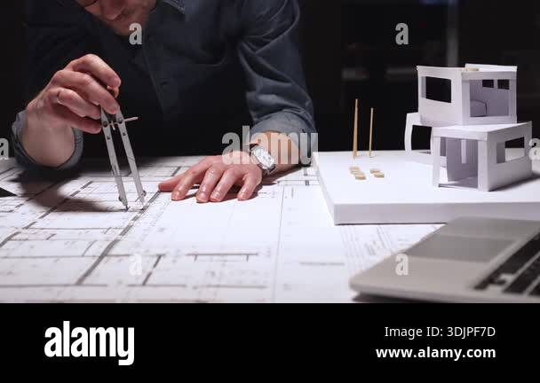 Designer or architect working on a laptop, drawing plans and ...