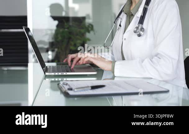 Healthcare professional using laptop for medical data entry, digital ...
