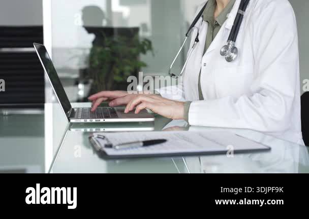 Healthcare professional using laptop for medical data entry, digital ...