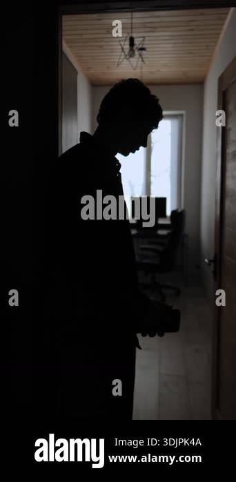 Young man silhouette receiving bad news on phone in doorway of home ...