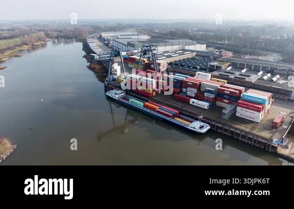 Aerial view of river port with colorful containers, docked cargo ship ...