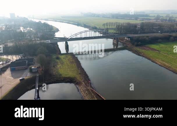 Aerial view of arched bridge over curving river in rural landscape ...