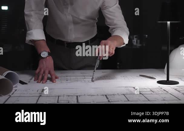 Architect drawing detailed building plans with a ruler and pen ...
