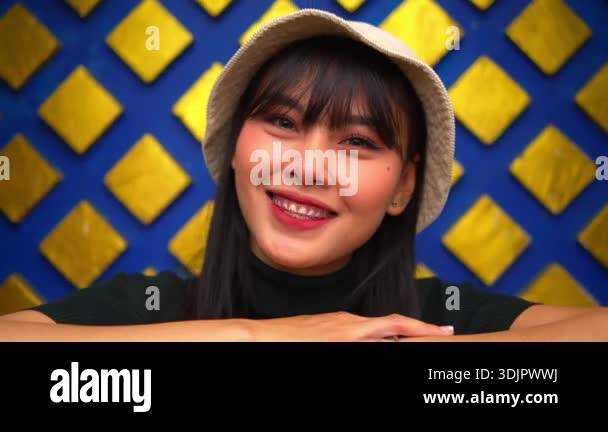 Close-up portrait of a lovely young Asian woman in a bucket hat ...