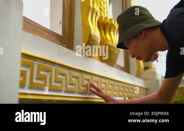 Close-up shot of a young man's hand gently touching the intricate ...