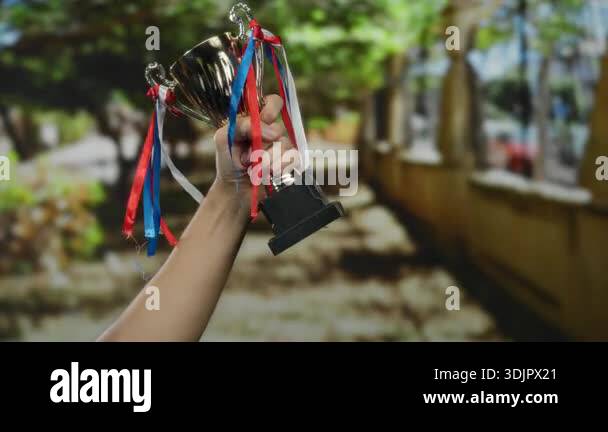 Hand of caucasian man holding trophy on city street outdoors ...
