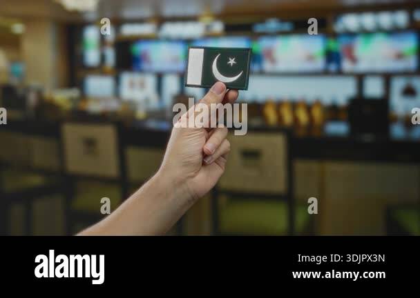 Man holding embroidered pakistan flag patch indoors in a coffee ...