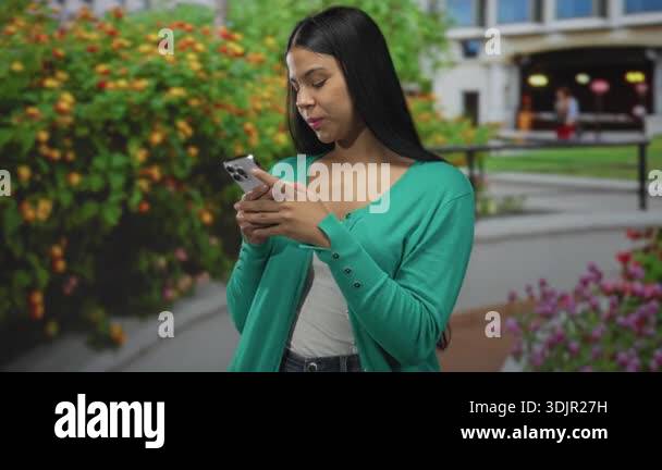 Woman holding smartphone with fingers tapping screen in building ...
