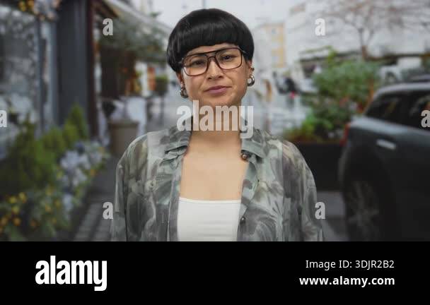 Young chinese woman wearing glasses pointing at nose with a smile while ...