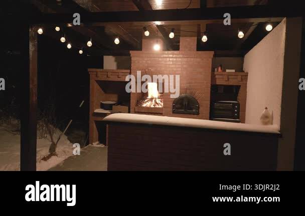 Timelapse of lighting a fire in an outdoor winter kitchen at night ...