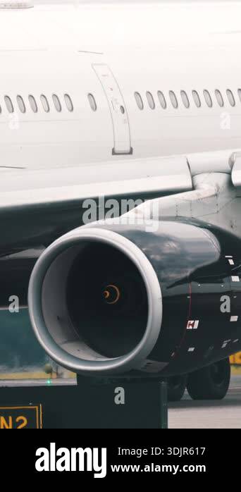 Jet engine running on an airplane wing with blurred red safety cones in ...