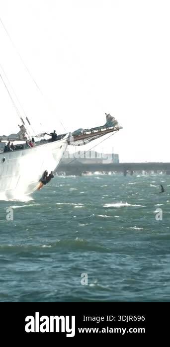 Majestic sailing ship braves choppy waters, with crew visible on deck ...