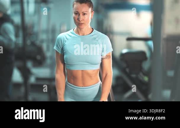 Toned athletic woman performing a dumbbell lateral raise exercise for ...