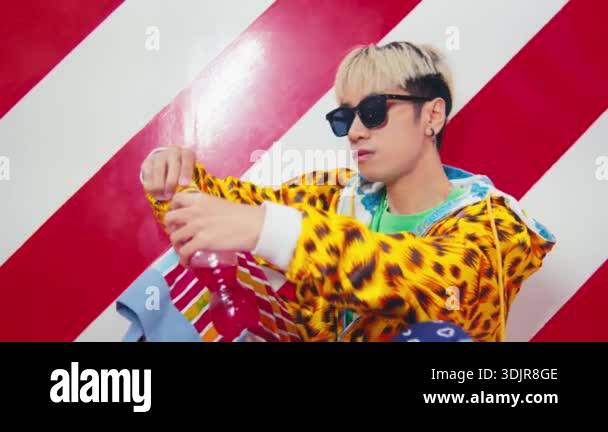 A trendy man in a leopard print jacket and sunglasses opens a ...