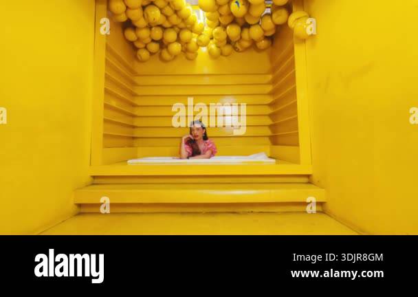 Symmetric shot of a young woman leaning in a bathtub with dozens of ...