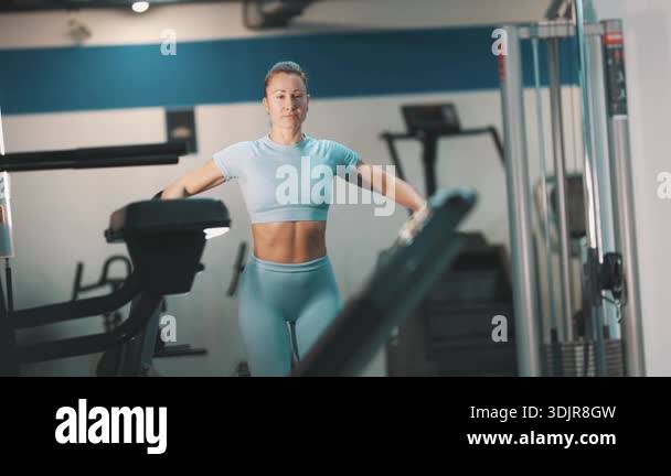 Determined athletic woman performing lateral raises with dumbbells for ...