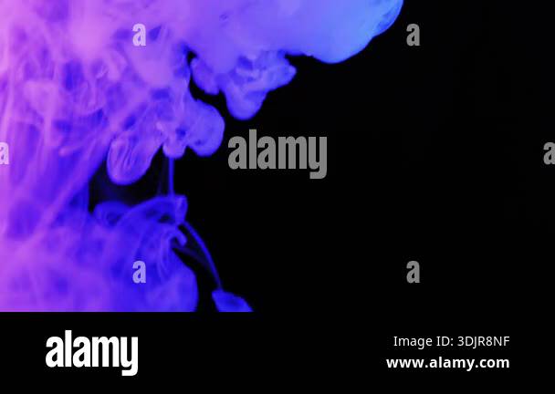 Billowing cloud of purple and blue smoke spreads against a black ...