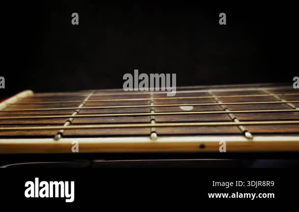 Acoustic guitar fretboard with metal strings and frets shown in extreme ...