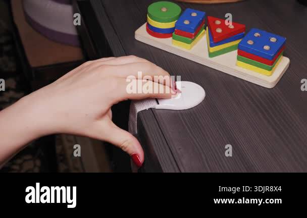 Womans hand with red manicure demonstrates a child proof strap lock on ...