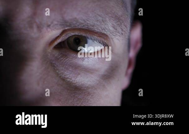 Caucasian male eye blinks and shifts gaze in extreme close-up view ...
