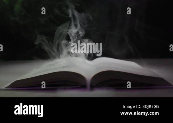 An open hardcover book sits on a table while thick smoke rises from its ...