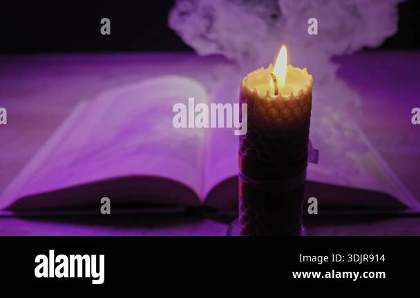 Textured beeswax candle burns with thick swirling smoke near an open ...