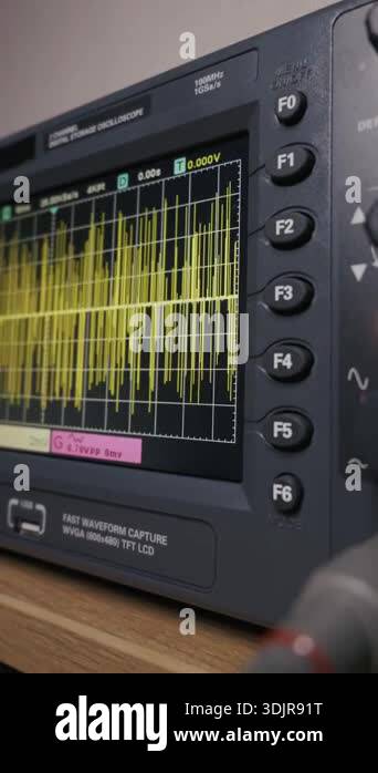 Close-up of a digital oscilloscope screen showing a noisy yellow ...